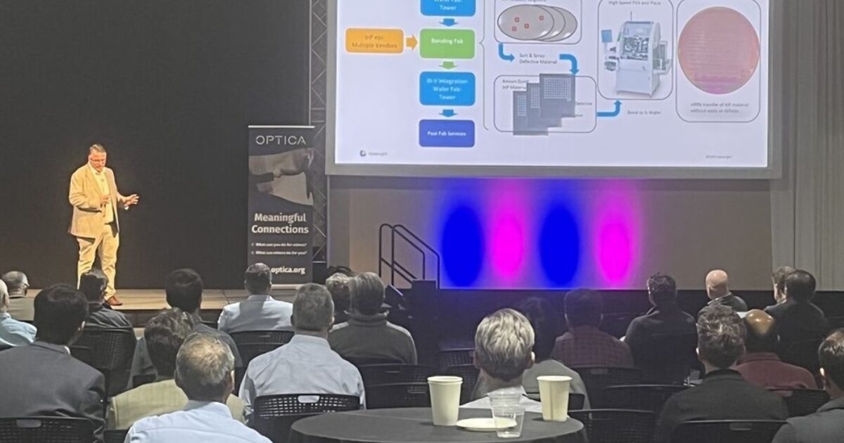 Dr. Adam Carter speaking at the Optica PECC… | OpenLight Photonics